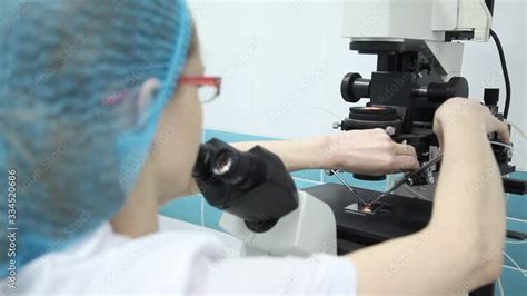 A Medical Worker Woman Sitting At A Large Microscope And Analyses The Semen Analysis A Nurse