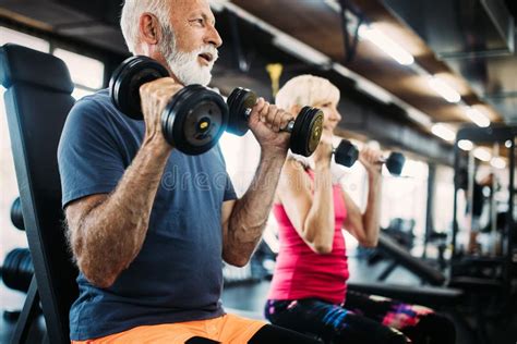 Senior Fit Man And Woman Doing Exercises In Gym To Stay Healthy Stock
