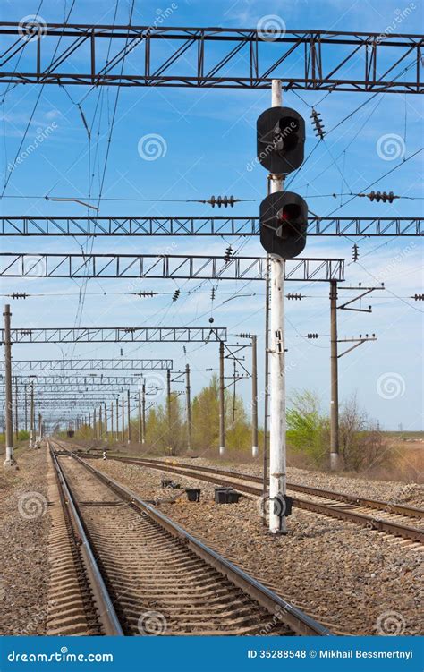 Red Signal Of Semaphore And Stop Sign In Front Of Railroad Crossing With Train Passing Stock
