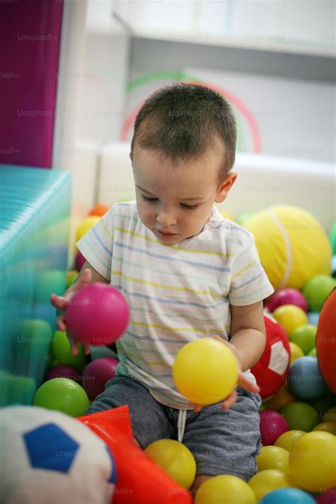 놀이터에서 어린 소년입니다 백인 어린 소년이 색깔 있는 공을 가지고 노고 있다 사진 Unsplash의 세르비아 이미지