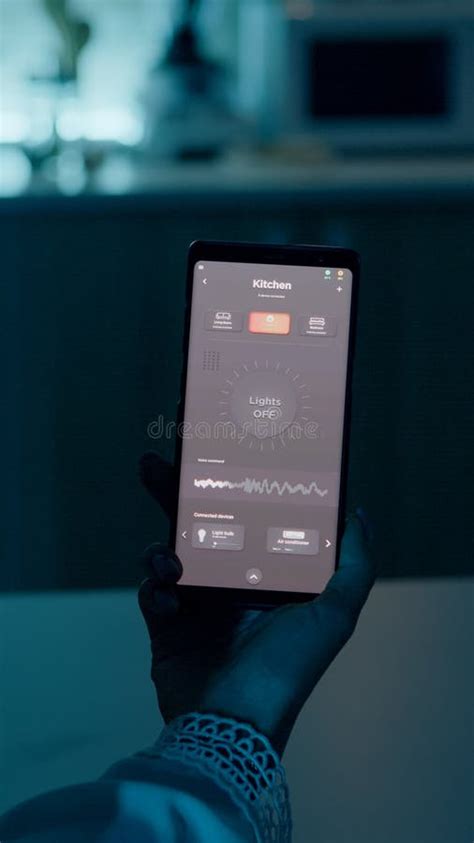 Woman Sitting In House With Automation Light System Holding Smartphone