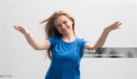 따뜻한 포옹을 해주세요 친절한 귀여운 금발 여학생이 카메라를 향해 손을 당기고 행복에서 미소 짓고 회색 배경을 통해 남자 친구와 껴안고 싶어하는 스튜디오 샷 제스처에 와서