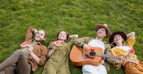 푸른 잔디밭에 수박과 기타를 들고 함께 누워 여름을 보내는 네 명의 젊은 친구 위에서 본 풍경 복사 공간 사진 Unsplash의 성인 이미지