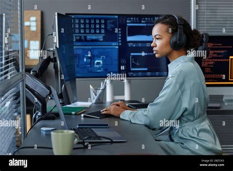 Young Computer Programmer Wearing Wireless Headphones Working On