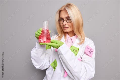 Female Laboratory Worker Observes Chemical Processes Focused At Glass Flask With Red Liquid