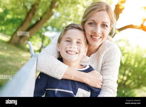Portrait Of Mother And Son Sitting On Bench In Park Stock Photo Alamy
