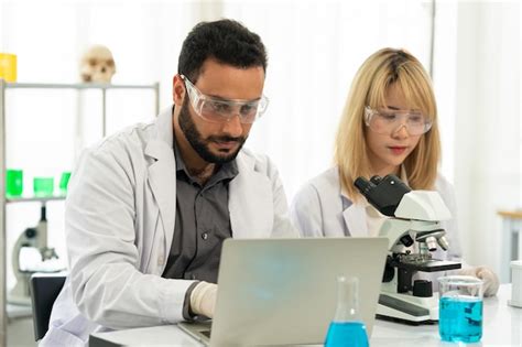 Premium Photo Lab Worker Using Magnifying Glass On Microscope