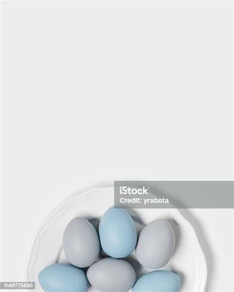 염색 부활절 달걀 파스텔 색상은 파란색 둥근 흰색 접시에 회색입니다 행복한 부활절 휴일 개념 축하 음식 장식 닭고기 달걀 중립 트렌디 한 컬러 카드 평면도 테이블 0명에