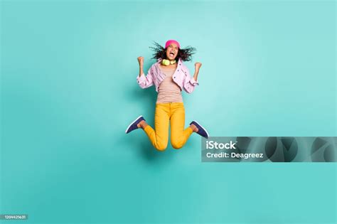 전체 길이 바디 사이즈 사이드 프로필 사진 캐주얼 긍정적 인 점프 실행 여학생 노란 바지 핑크 재킷 티셔츠 고립 선명한 색상 청록색 배경에 시간에 교육 단지에 와서 열망