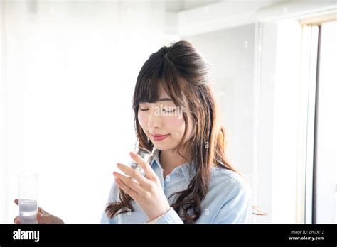 Woman Smelling Aroma Oil From A Beaker Stock Photo Alamy
