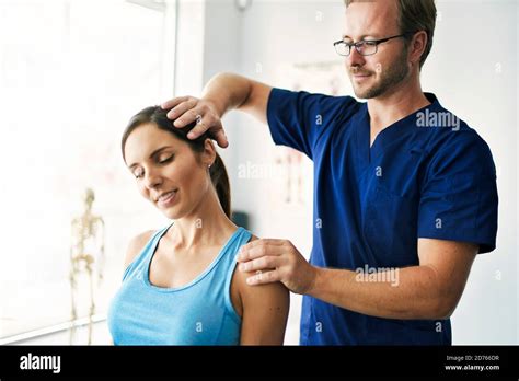 Male Physical Therapist Stretching A Female Patient Nack Stock Photo Alamy