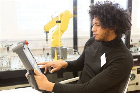 engineer programming industrial robot with gripper arm for automated