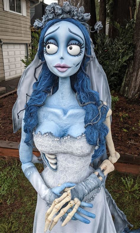 A Corpse Bride With Blue Hair And Makeup Is Standing In Front Of A