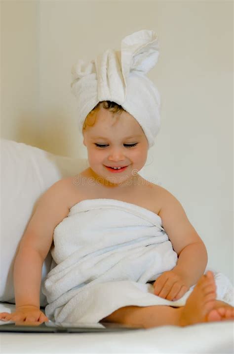 Cute Portrait Of A Young Girl Getting Out Of The Bath And Playing With A Touchpad In The Bedroom