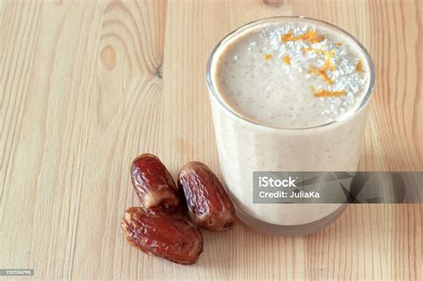 건강 한 유기농 데이트와 오렌지 밀크 스무디 가루 잘게 썬 코코넛과 오렌지 껍질 신선한 다이어트 아침 식사 나무 배경입니다 선택적 초점 대추 열대 과일에 대한 스톡 사진 및