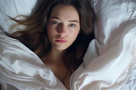 Premium Photo A Beautiful Young Woman Laying In Bed Under A Blanket