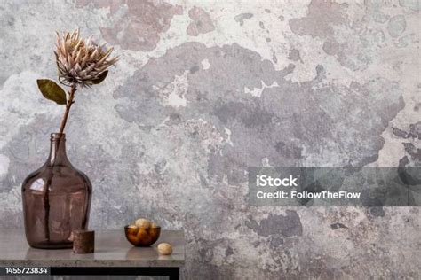 복사 공간 정사각형 테이블 꽃이 있는 유리 꽃병 회색 콘크리트 벽 그릇에 담긴 땅콩 개인 액세서리가 있는 현대적인 아파트의 로프트 스타일 가정 장식 템플렛 디자인에 대한