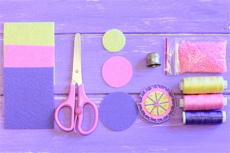 펠트와 구슬로 만든 예쁜 둥근 꽃 컬러 펠트 원과 시트 가위 실 스풀 세트 바늘 나무 테이블에 분홍색 구슬 손바느질 가이드 상의 View 0명에 대한 스톡 사진 및 기타