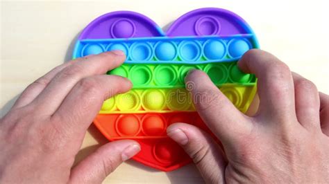 Close Up Of A Females Hands Playing With A Popit On Yellow Background Girl Plays Popit Stock