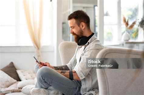 집에서 소파에서 쉬는 동안 디지털 태블릿을 사용하는 잘 생긴 수염을 가진 남자 30 34세에 대한 스톡 사진 및 기타 이미지 30 34세 거실 경영자 Istock