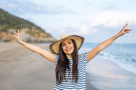 Mature Woman Enjoying On The Beach Spread Her Arms In The Gentle Breeze