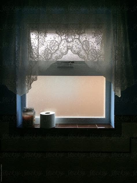 A Bathroom Window Letting In Evening Light By Stocksy Contributor TJ Macke Stocksy