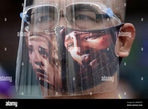 A Devotee Of The Black Nazarene Wears A Mask With The Faces Of Jesus