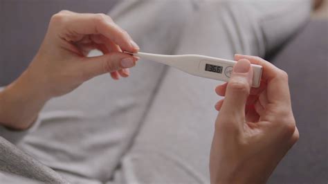 Woman Measuring Normal Body Temperature Using An Electronic Thermometer Stock Video Footage 00