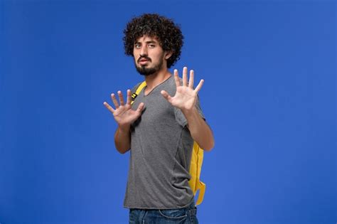 Vista Frontal De Um Jovem Do Sexo Masculino Em Uma Camiseta Cinza Usando Uma Mochila Amarela