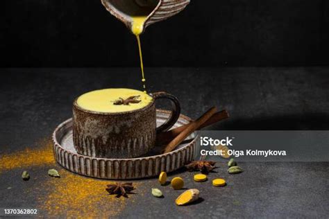 심 황 분말과 신선한 심 황 뿌리와 아니스와 계피 블랙 황금 우유의 컵 향신료와 허브의 개념 어두운 배경에 아유르베다 음료 텍스트 공간입니다 손으로 만든 양념류에 대한 스톡