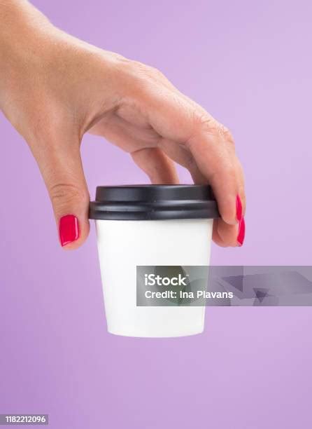 분홍색 배경에 고립 된 작은 종이 커피 컵과 여성의 손 복사 공간이 있는 화이트 에스프레소 컵 모형 공란에 대한 스톡 사진 및
