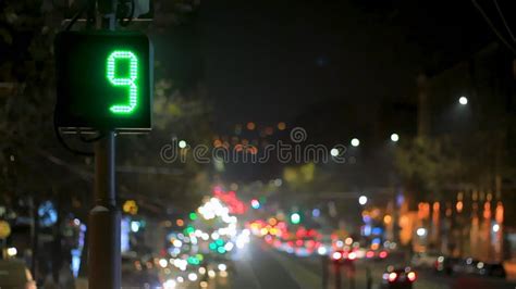 Traffic Light With Green Countdown Timer Against The Backdrop Of A Night City Blurred Moving