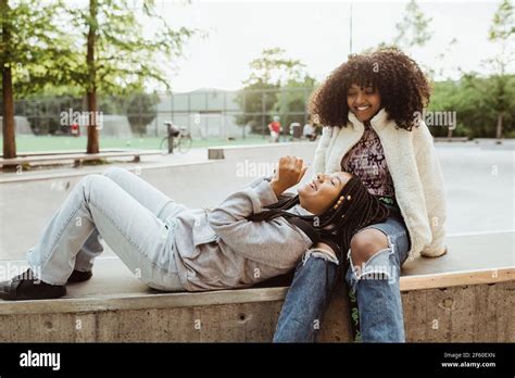 Teenage Girl Resting Head On Female Friends Lap While Sitting On