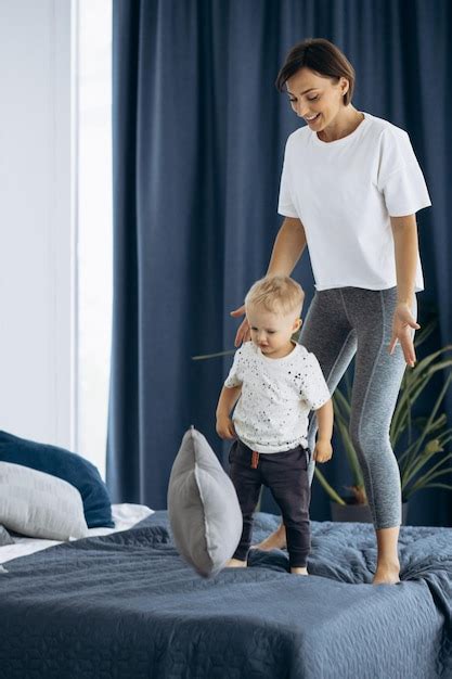 Madre Con Su Peque O Hijo Saltando En La Cama Foto Premium