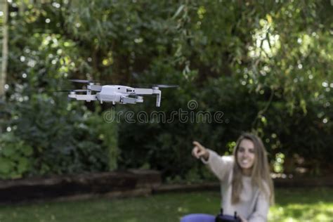 Selective Focus On Flying Drone And Blurred Young Woman Pointing The
