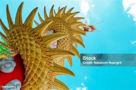 푸른 하늘과 흰색 구름 배경에 고립 된 붉은 기둥 주위에 규모의 아름다운 패턴과 황금 중국 용 동상 중국 새해 축하 장식 건축에