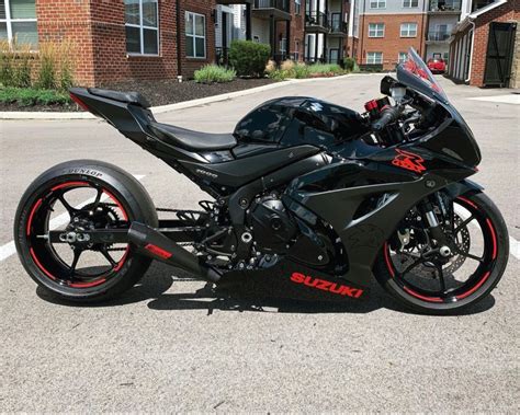 Black And Red Motorcycle Parked In Front Of Buildings Black Suzuki