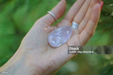 Vumfit Imbuilding 또는 명상을위한 투명 자수정 석영 요니 계란여성의 손 야외에서 하늘과 일출 배경에 손에 빛나는 크리스탈 계란 여성 건강 개념 건강한 생활