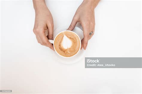 카페에서 뜨거운 맛있는 커피와 함께 빈티지 컵을 들고있는 젊은 여성의 손 흰색 배경에 여성 손에 카푸치노에 대한 상단보기 미니멀리즘과 음료 기포 음료에 대한 스톡 사진 및