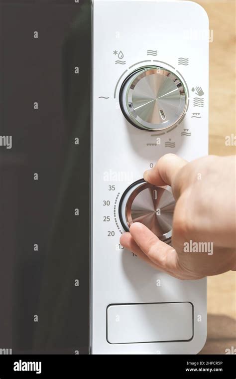 Hand Using An Oven Girl Adjusting Temperature Of Microwave Oven Using Microwave Oven Power