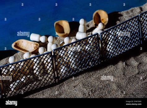 Conceptual Migration Symbol Figures And Boats Behind A Fence Stock