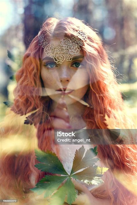 이중 노출 및 섬광 자연 빨간 머리 여자의 멋진 초상화 숲 신비한 모습에 큰 눈 긴 머리를 가진 아름 다운 빨간 머리 소녀 나뭇잎과 풀을 그녀의 얼굴에 가을에 대한 스톡