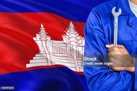 블루 유니폼 크메르어 정비사는 캄보디아 국기의 배경을 흔들며에 대 한 렌치를 들고 있다 교차 무기 기술자 교통수단에 대한 스톡