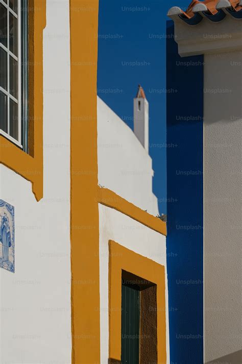 배경에 시계탑이 있는 흰색과 노란색 건물 사진 Unsplash의 화려한 외관 이미지
