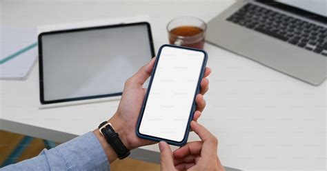 현대적인 사무실 책상에 앉아 휴대폰을 들고 있는 사업가의 모습을 닫습니다 사진 Unsplash의 태국 이미지