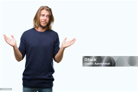 발생 하는 손과 팔으로 고립 된 배경 우 둔 하 고 혼란 스 러 워 식 이상의 겨울 스웨터를 입고 긴 머리를 가진 젊은 잘생긴 남자 의심 개념입니다 감정에 대한 스톡 사진