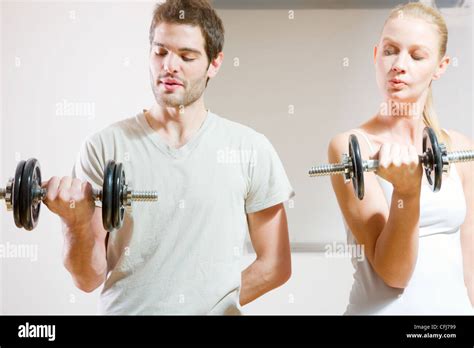 Man And Woman Lifting Dumbbell In Gym Stock Photo Alamy