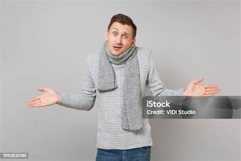 회색 스웨터에 당황한 젊은이 확산 손 회색 벽 배경 스튜디오 초상화에 고립 된 스카프 건강 패션 라이프 스타일 사람들 진심으