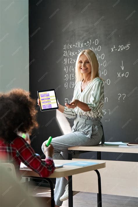 Premium Photo Smiling Teacher Having Maths Class Sitting On Desk