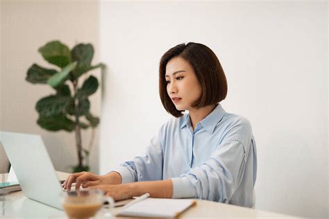 Serious Beautiful Woman Looking At Open Laptop Computer By Stocksy Contributor Marc Tran